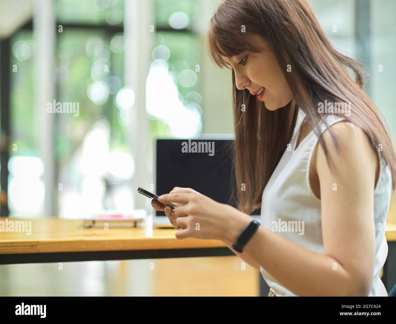 A beautiful young Asian woman using her smartphone in the room. chat ...