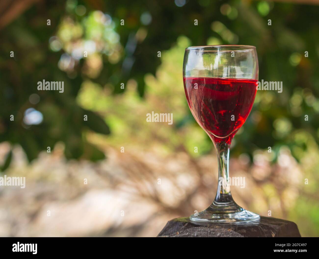 glass of red wine is placed on a wooden table. In the morning sea ...