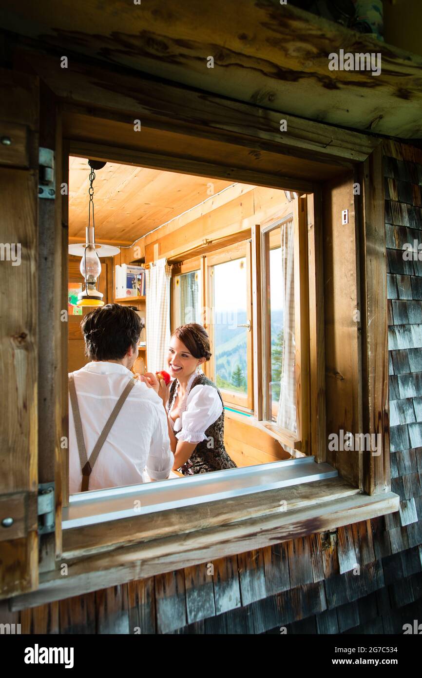 Couple in a traditional mountain hut having a meal - view through the ...