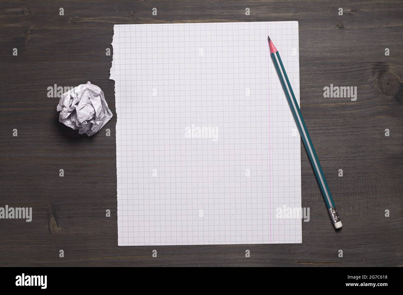 Empty sheet from school notebook, crumpled paper and pencil on dark ...