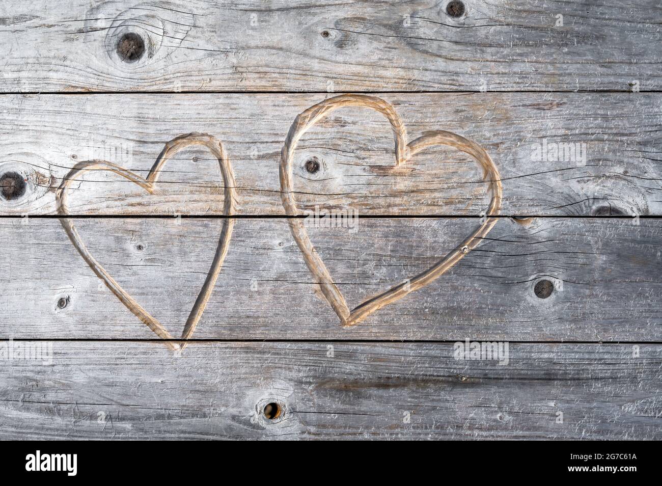 Two hearts carved in wood as a symbol for love and partnership as a ...