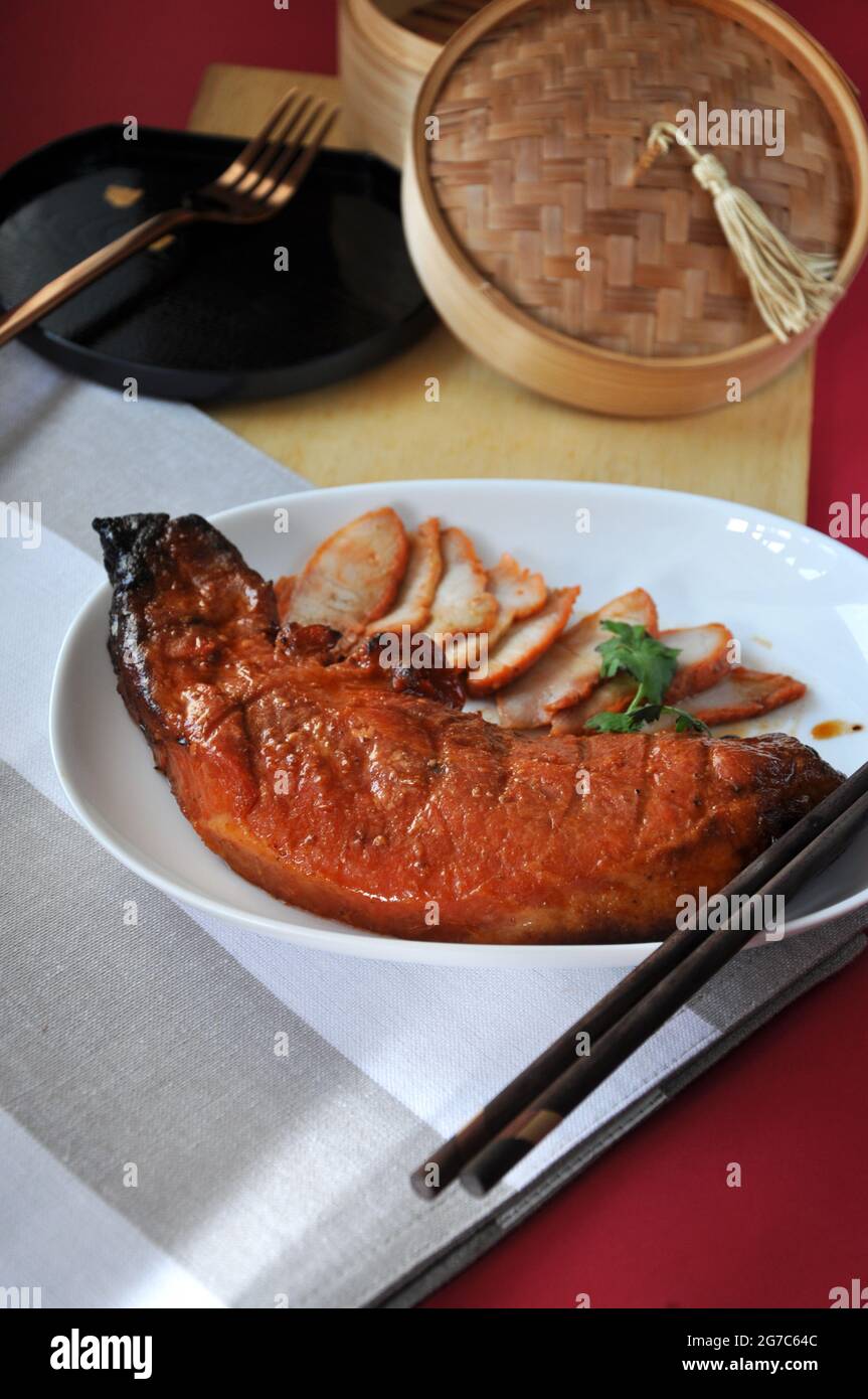 Dish of Chinese barbecue pork Char siu on red background Stock Photo ...