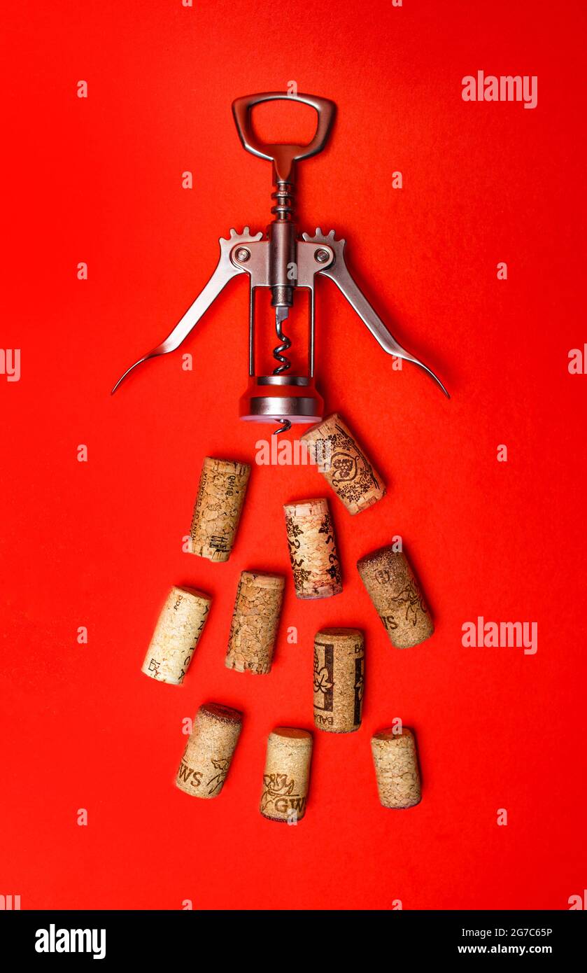 corkscrew for wine and corks on a red background Stock Photo - Alamy