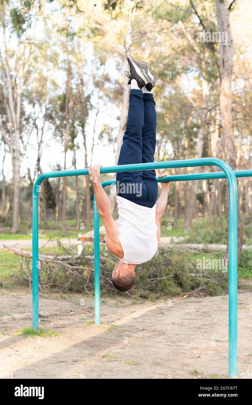 Male athlete exercising head to the ground on parallel bars Stock Photo ...