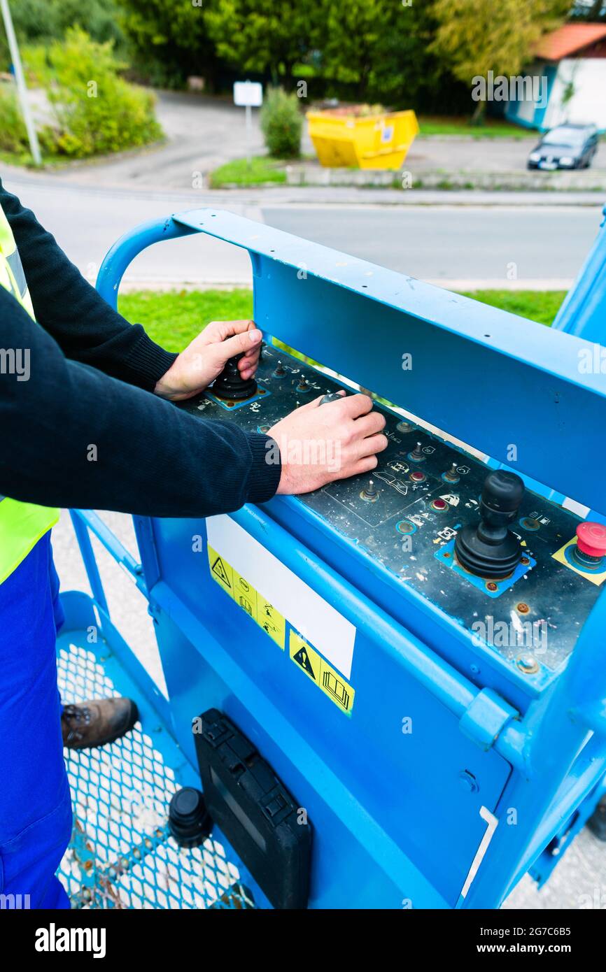 Construction workers or crane driver on site driving hydraulic lifting ...