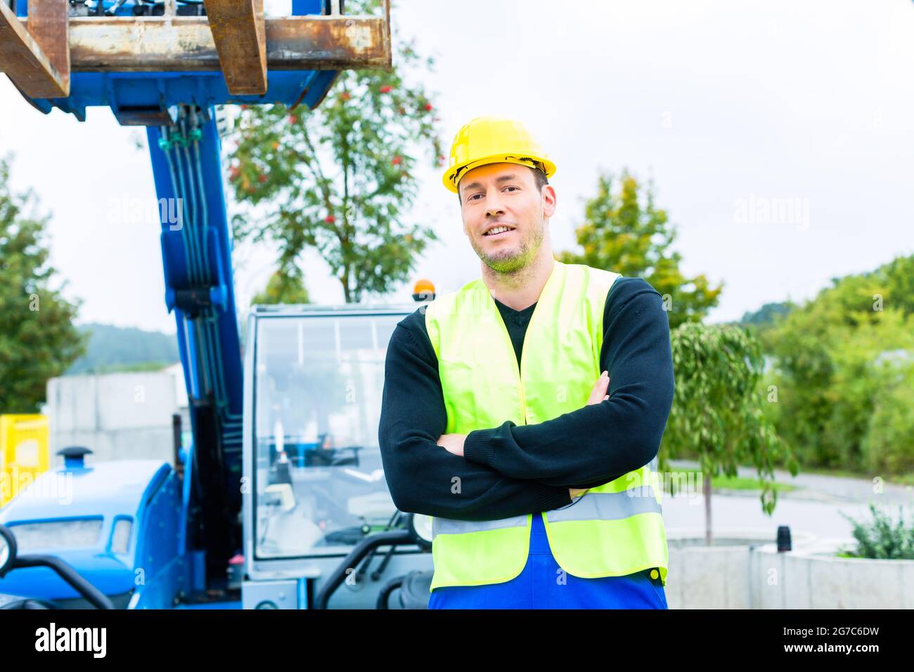 builder or driver driving excavator on construction or building site ...