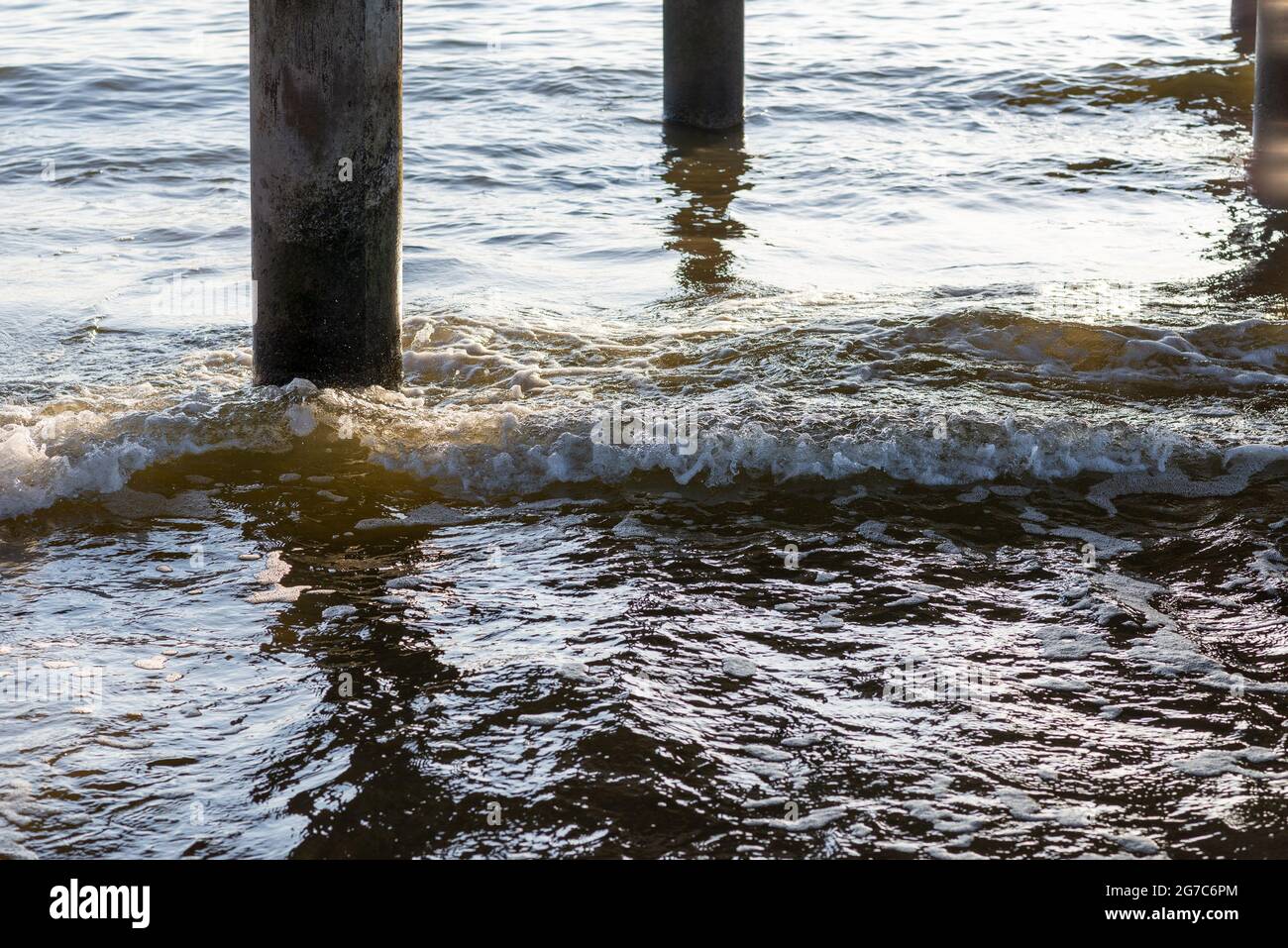 Columnar bridge piers at sunset.View under the bridge into sea with ...