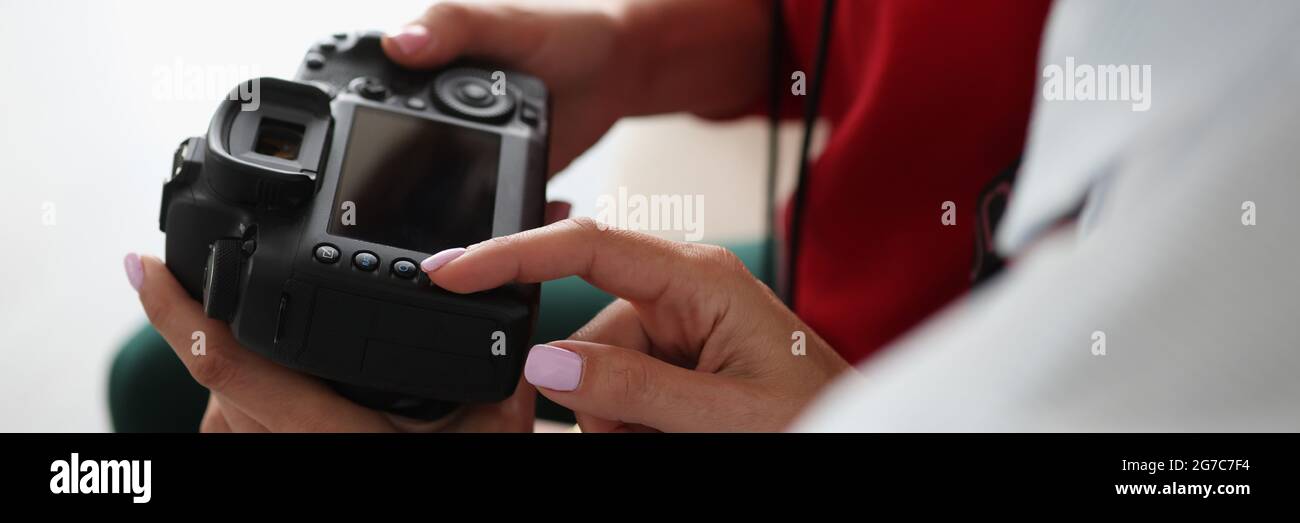 Two women hold camera in their hands Stock Photo - Alamy