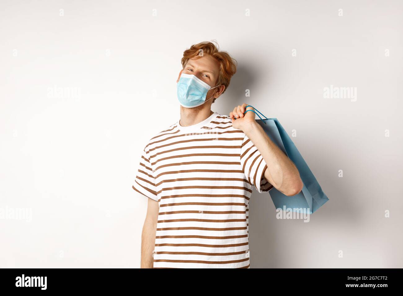 Concept of covid-19 and shopping. Satisfied young man looking pleased ...