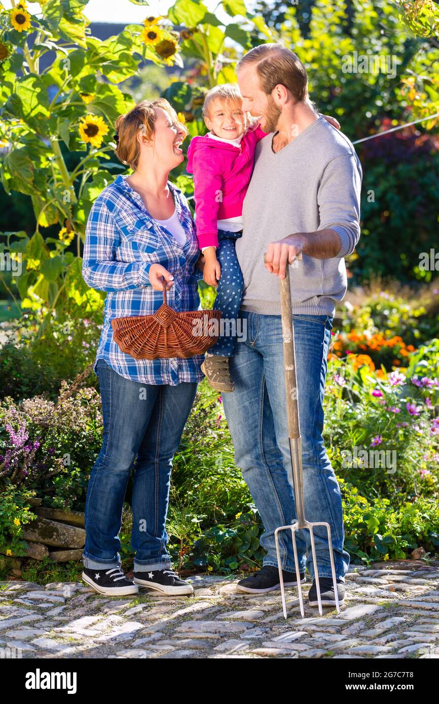 Family with mother, father and daughter gardening in garden Stock Photo ...
