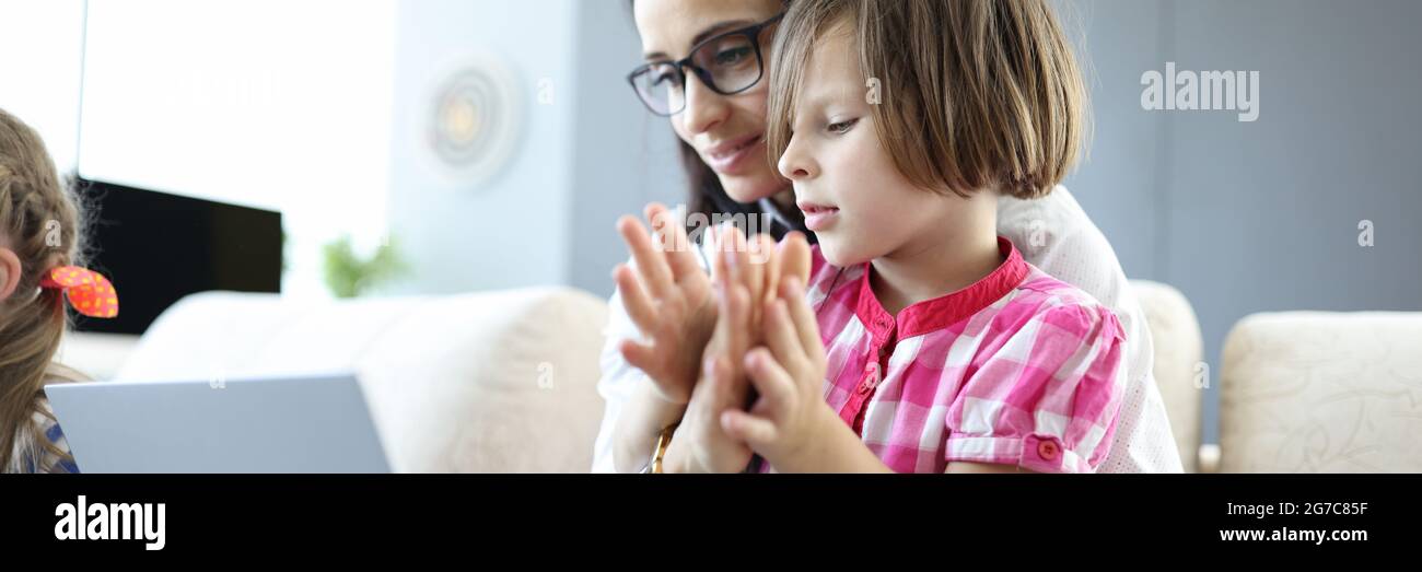 Woman holds laptop on lap of little girl sitting Stock Photo - Alamy