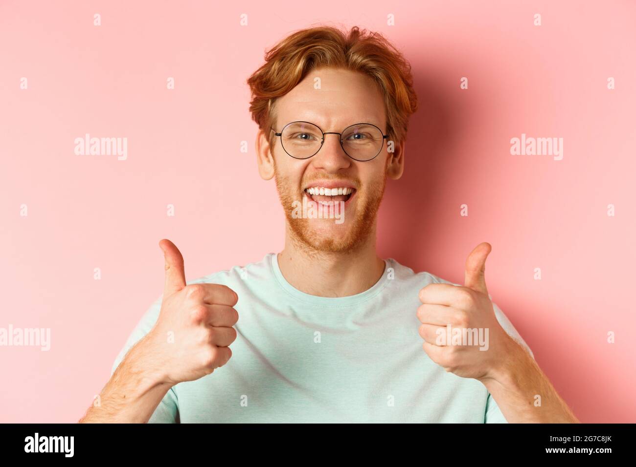 Face of satisfied male customer showing thumbs-up in approval, smiling ...