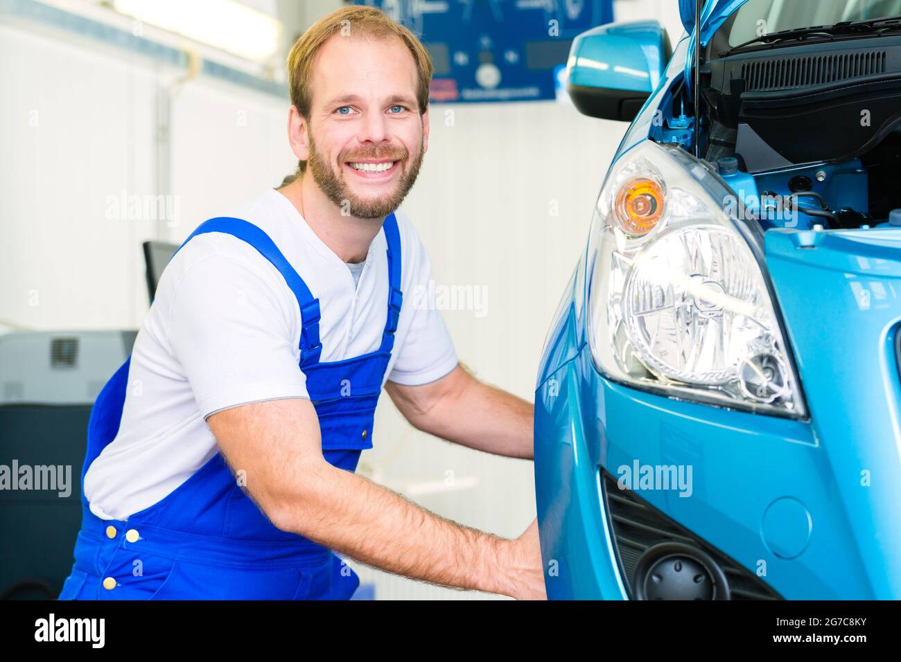Mechanic in workshop or MOT with car or auto for service inspection ...