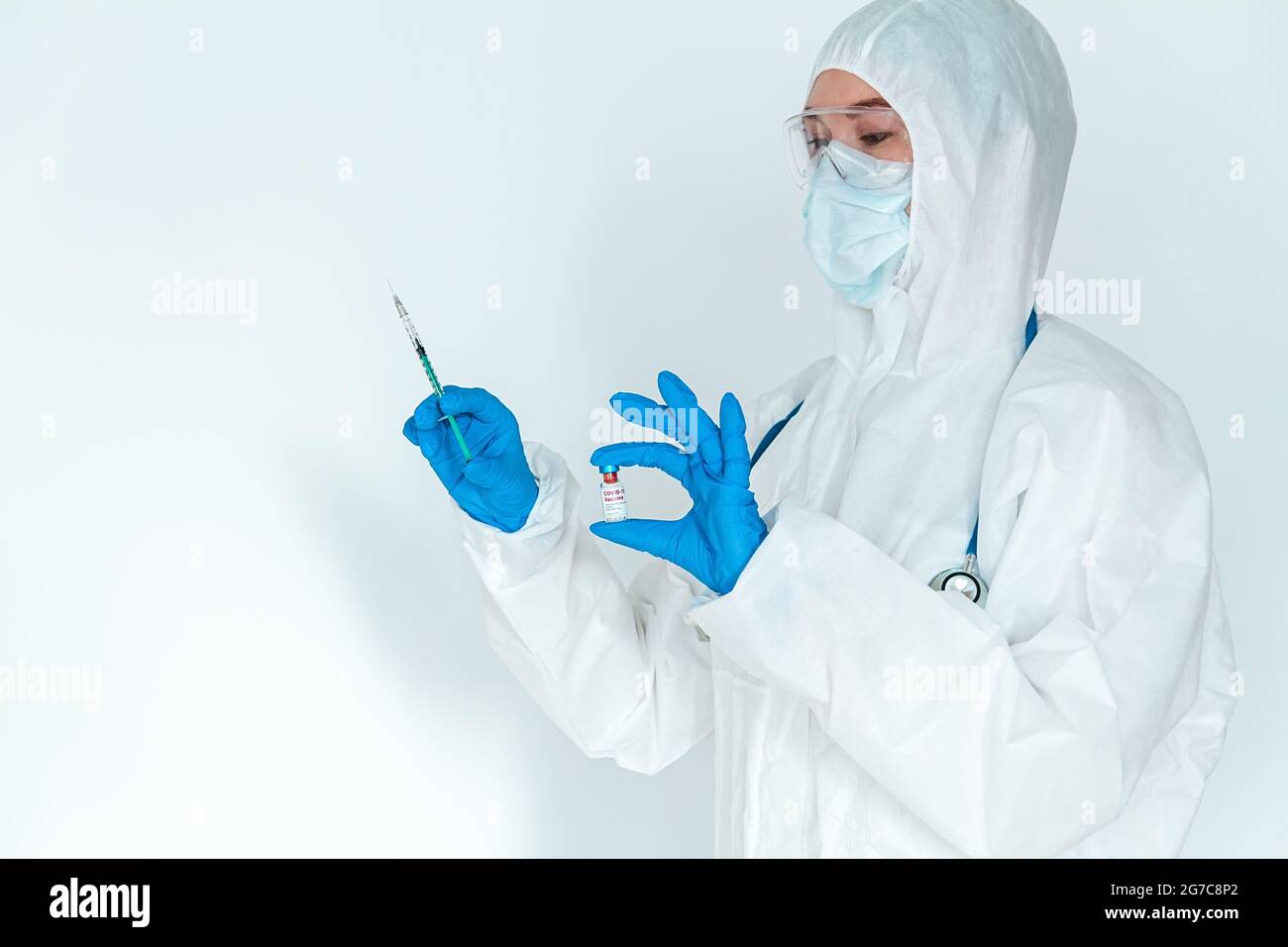 Doctor or nurse in a protective suit holds a syringe and covid 1 Stock ...