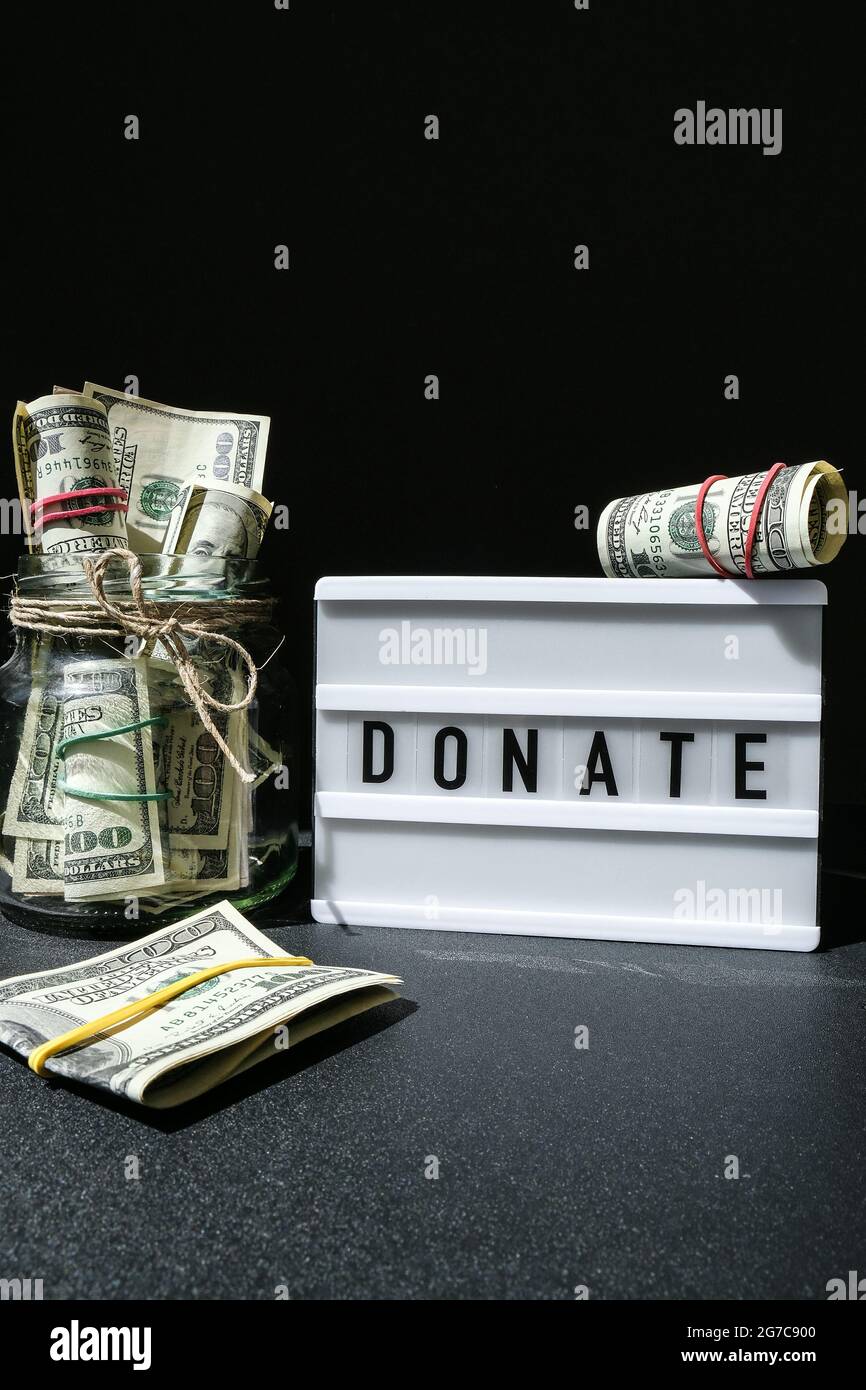 Lightbox board with word DONATE in black letters around US dollar ...