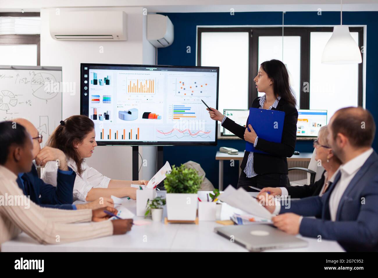 Young team leader in big corporation briefing coworkers pointing at ...
