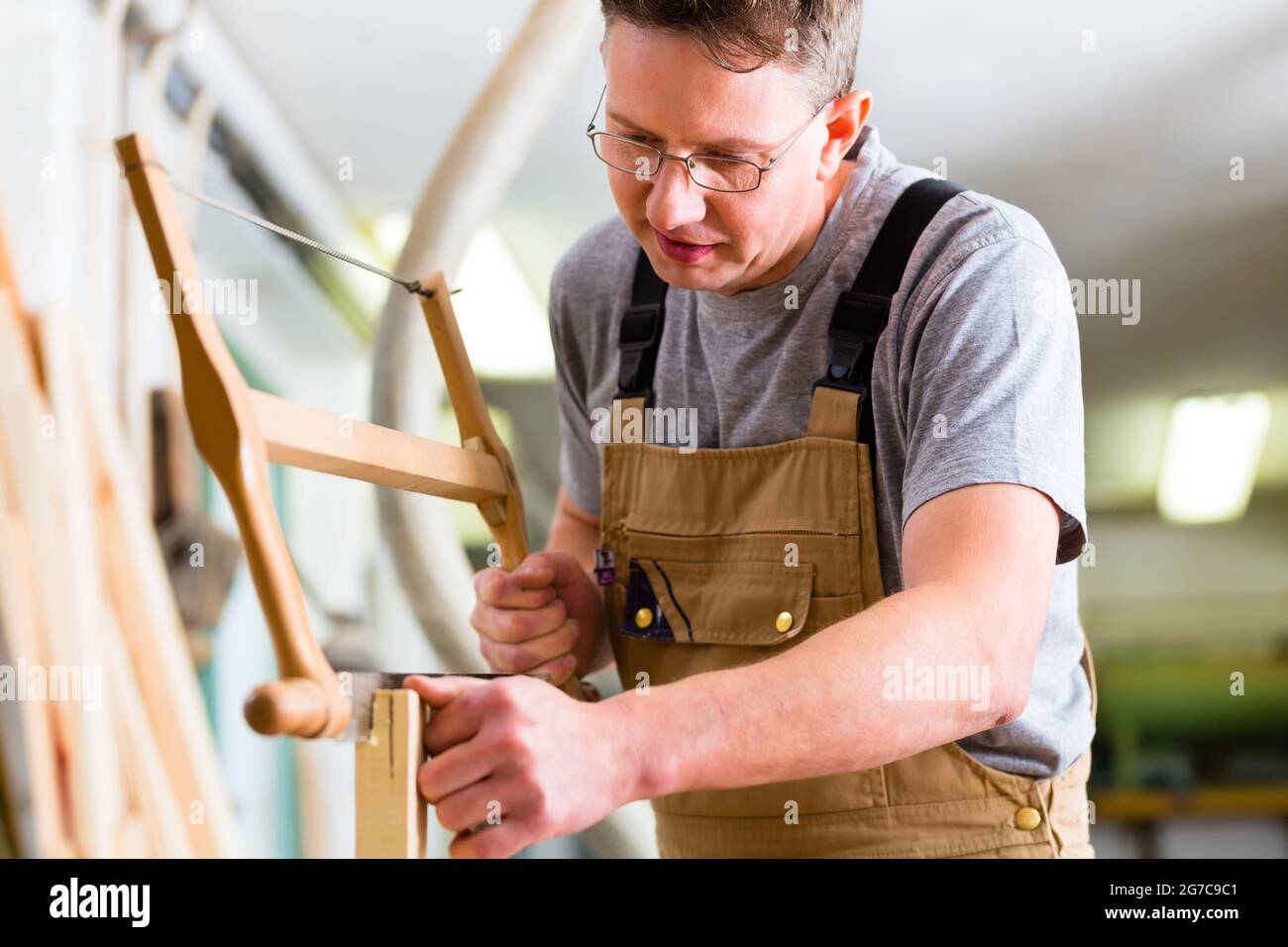 Carpenter working on a hand saw cutting a tenon in drawers in his ...