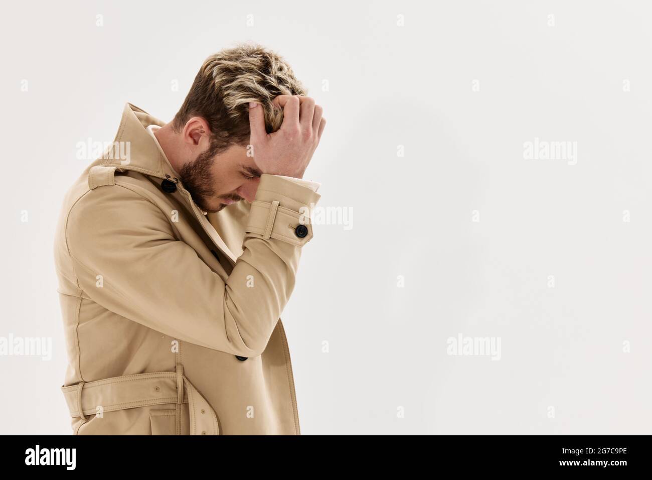 a man in a coat holds sleeves for the head fashionable hairstyle autumn ...