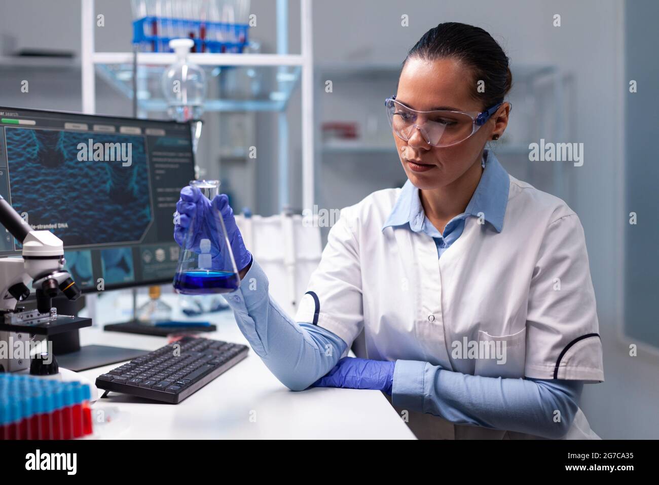 Scientist woman doctor holding glass flask analyzing liquid solution ...