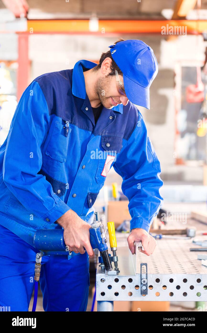 Craftsman rivet metal with air compressed pistol in workshop Stock ...