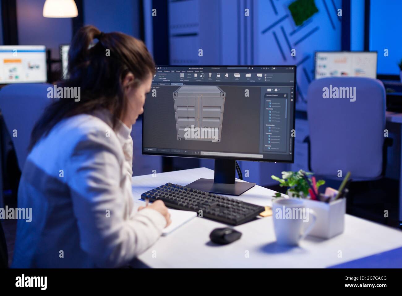 Focused architect working in 3D software developing prototype container ...