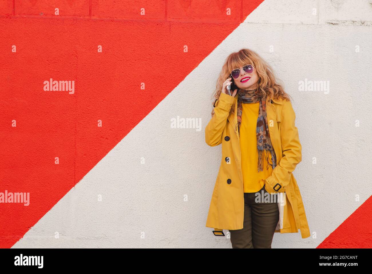 woman with mobile phone on the wall with red and white bands Stock ...