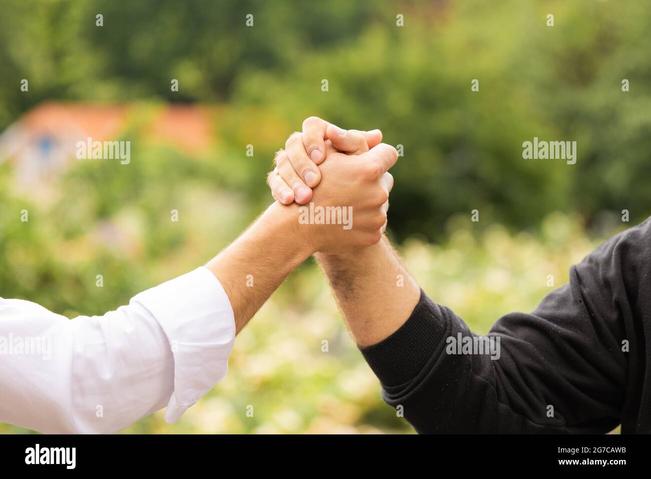 Oldenburg, Germany. 03rd July, 2021. ILLUSTRATION - Two men greet each ...