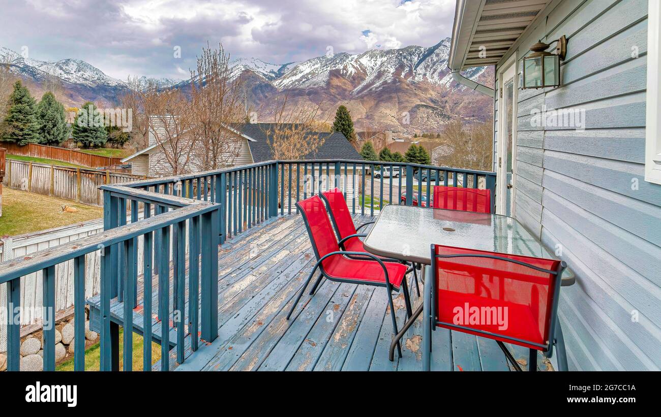 Pano Balcony of home with glorious views of snowy mountain peaks and overcast sky Stock Photo ...
