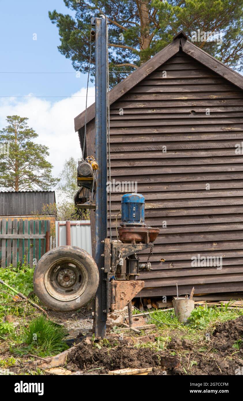 small-sized drilling rig. drilling water wells on a garden plot or a ...