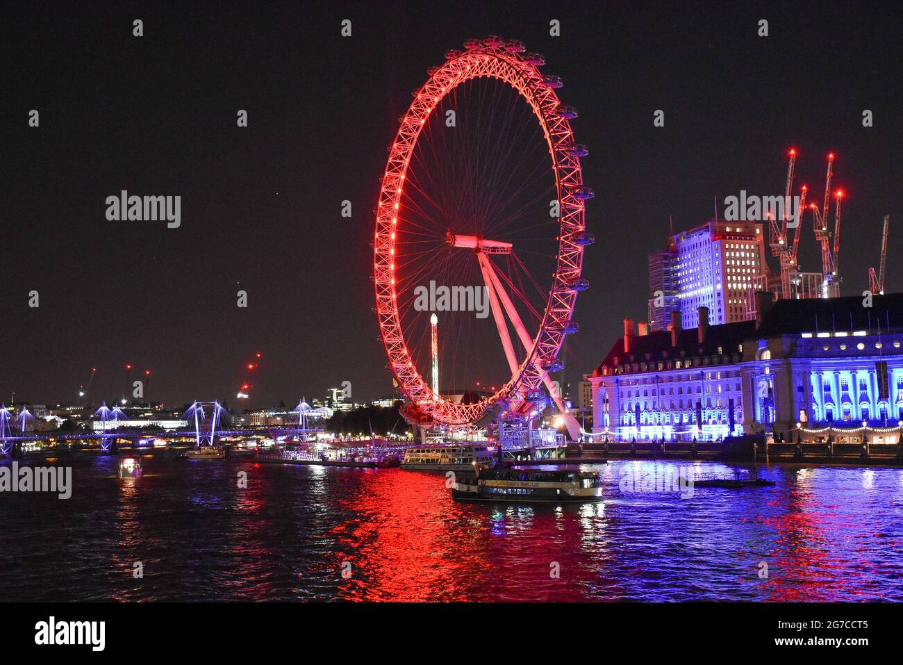 View of the River Thames at night with the London Eye illuminated in ...