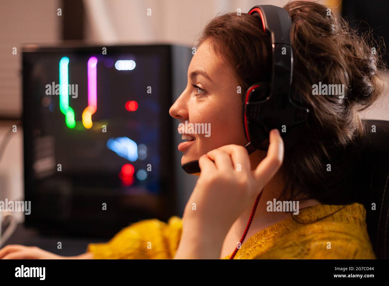 Pro gamer talking with teammates through headphones playing shooter ...