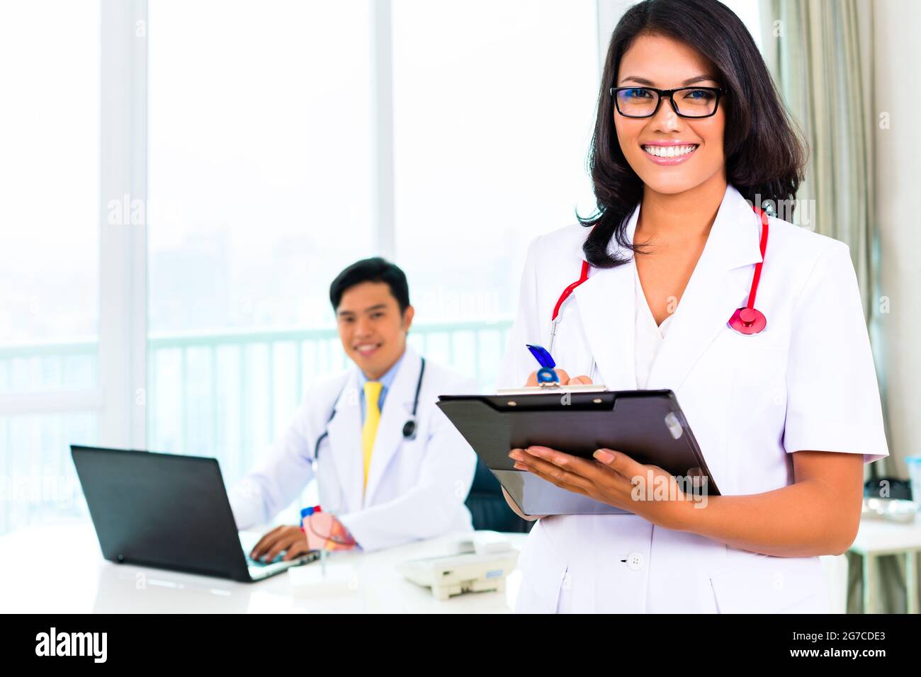Asian doctor and nurse working in medical office or practice Stock ...
