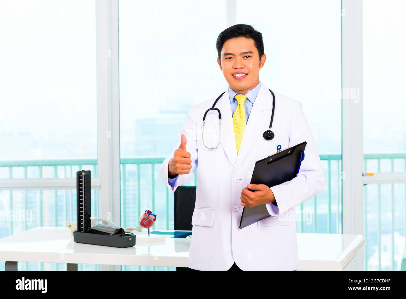Asian doctor standing proud in his office or medical practice Stock ...