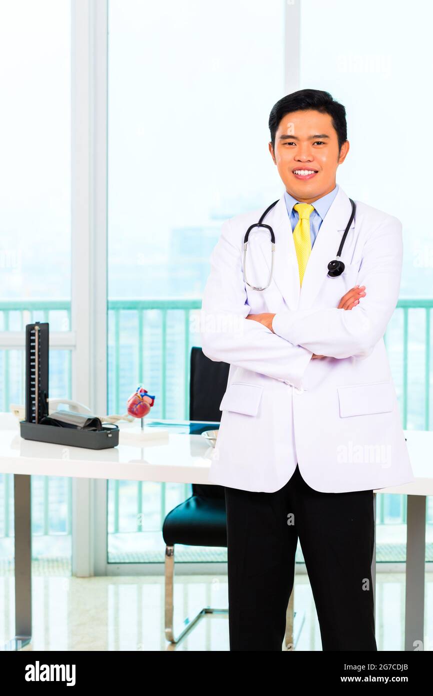 Asian doctor standing proud in his office or medical practice Stock ...