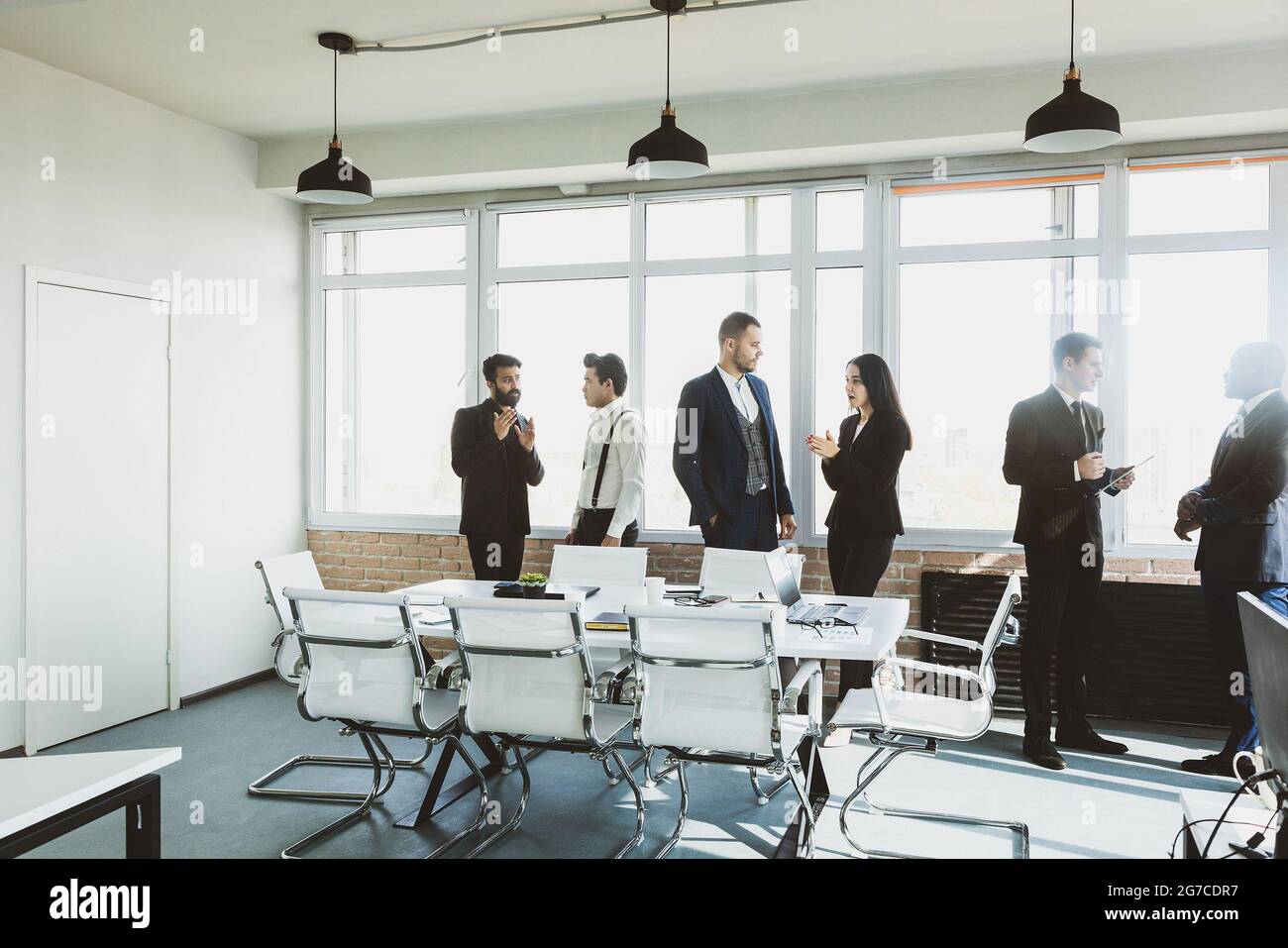 Silhouettes of people against the window. A team of young businessmen ...