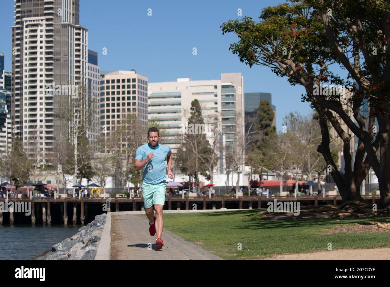 Sporty man runner running in summer. City run Stock Photo - Alamy