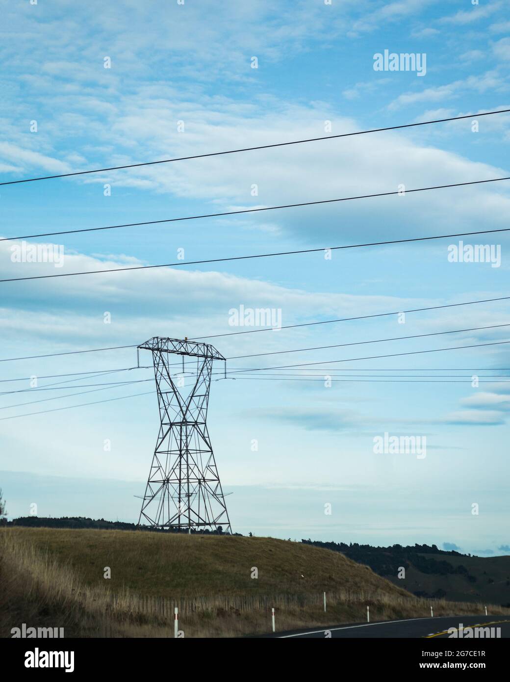 High voltage transmission towers and overhead powerlines against the ...