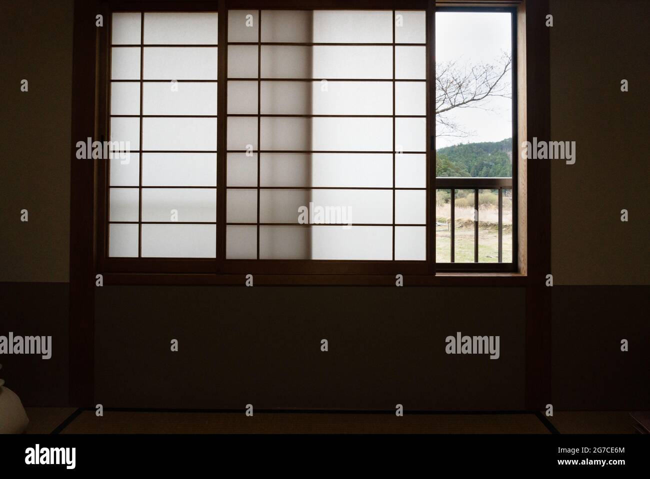 Traditional Japanese room with windows half open and tree branches ...