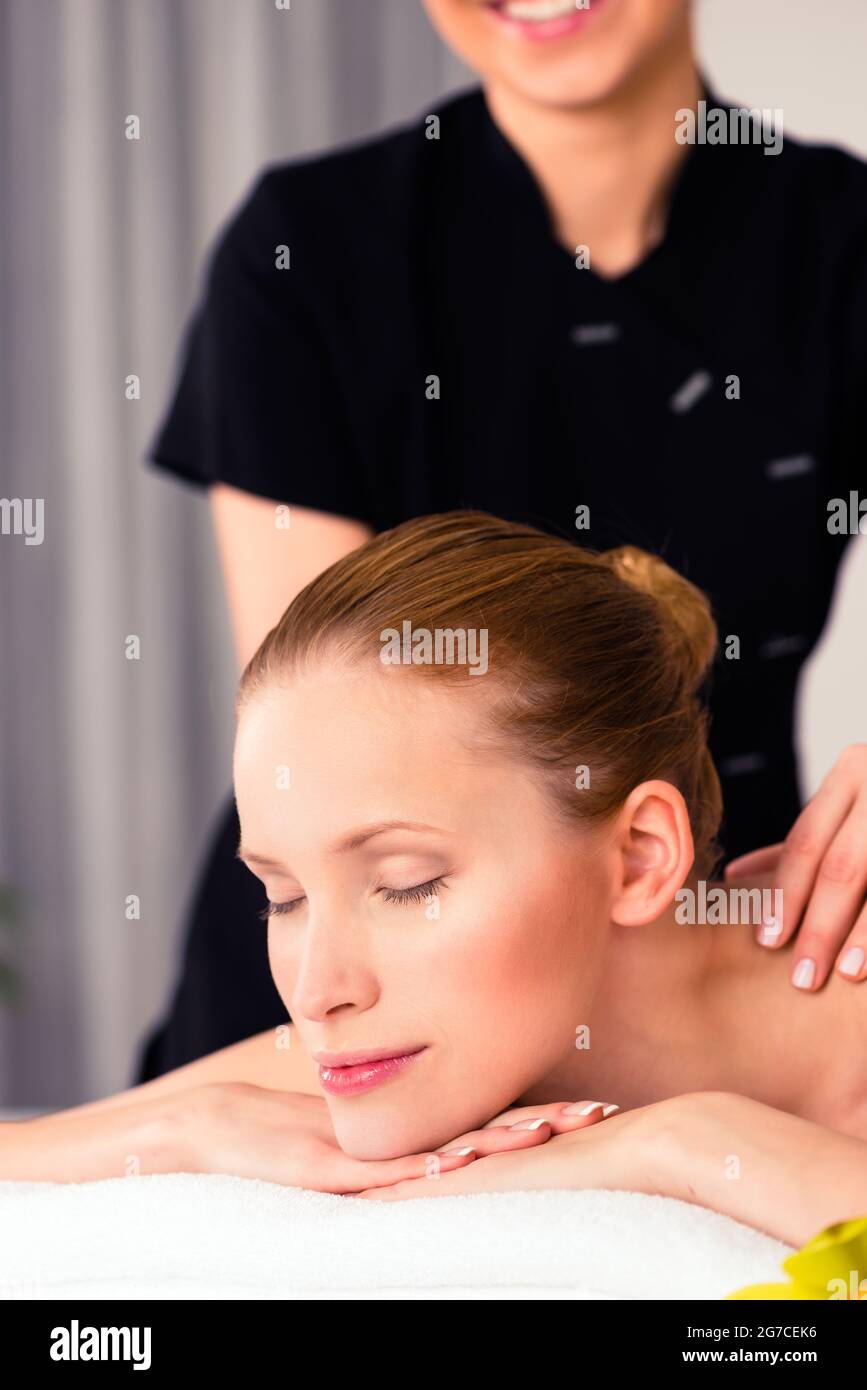 Massager giving woman in wellness beauty spa back massage with ...