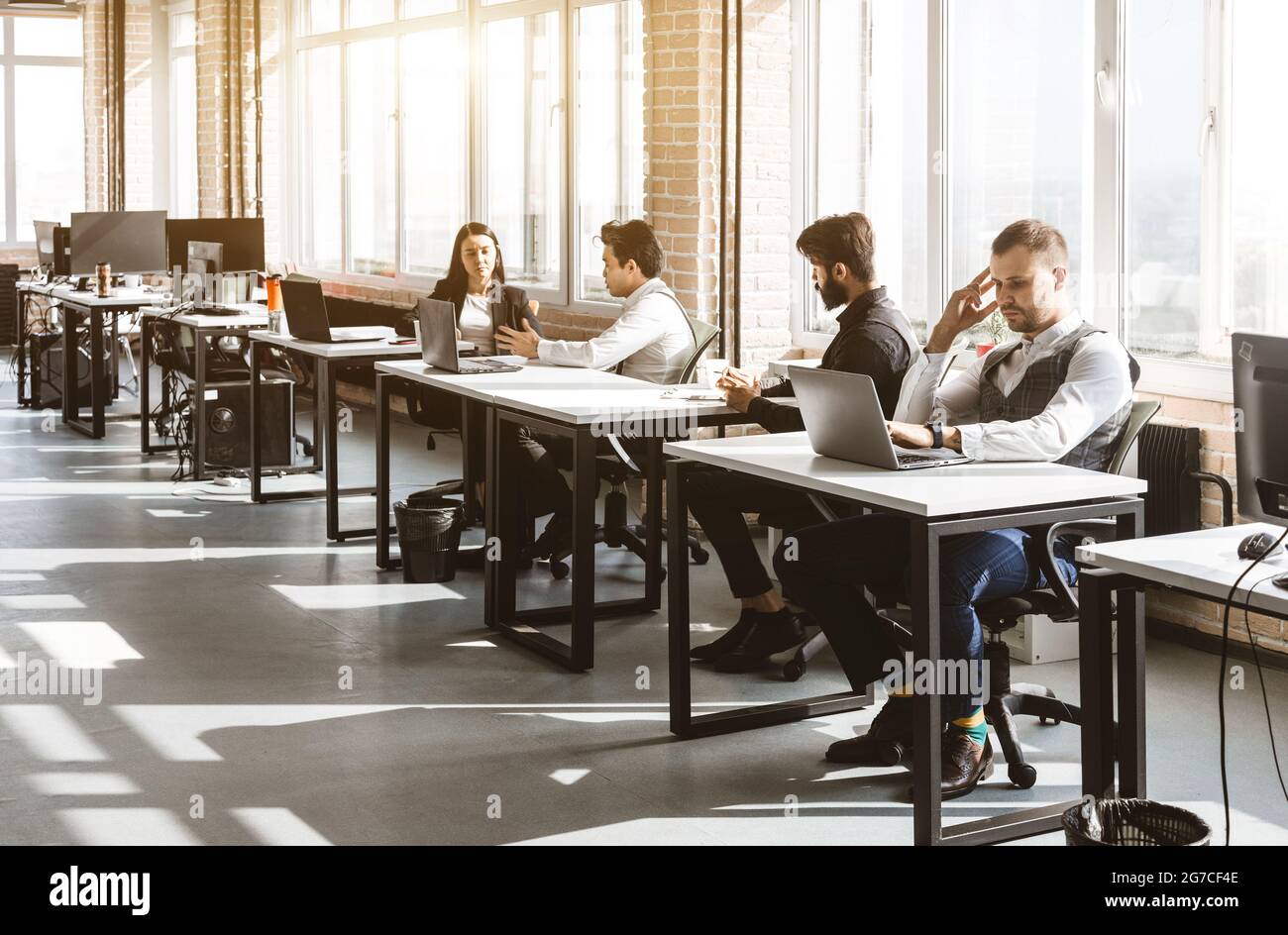 Group of young business people in smart casual wear working together in ...