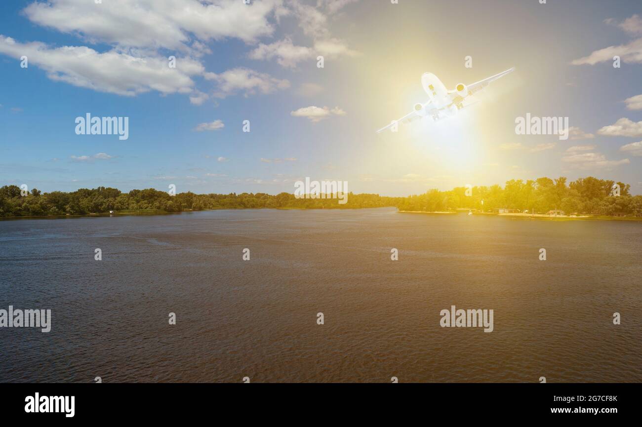Plane over the river and forest. The sun is shining brightly in the sky ...