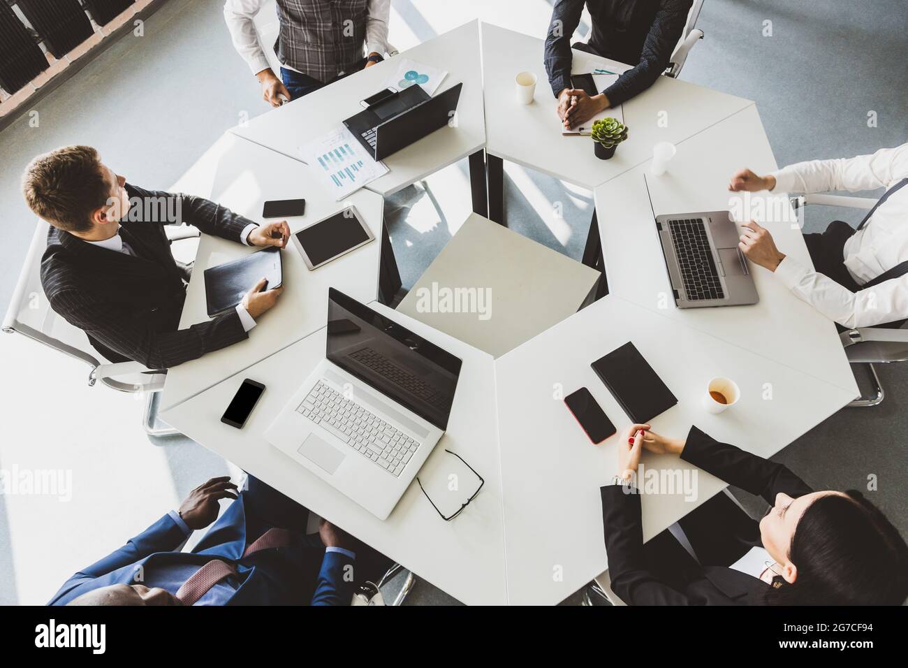 Group of young business people working and communicating while sitting ...