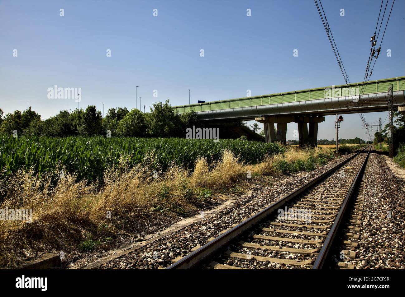 Railroad track that passes under a viaduct in the italian countryside ...