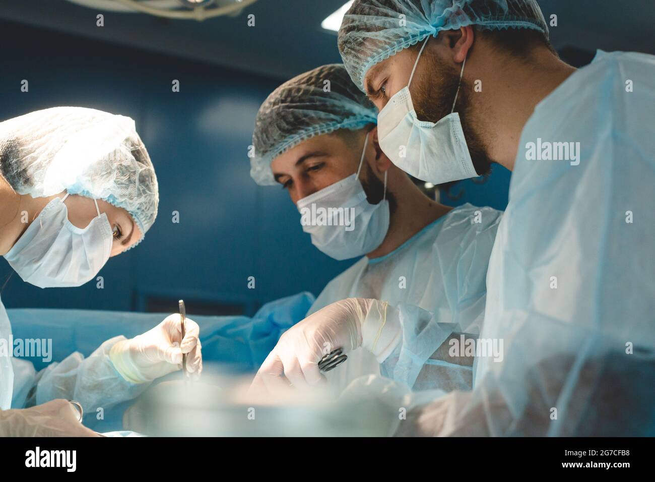 An international team of doctors performs a complex surgical operation ...