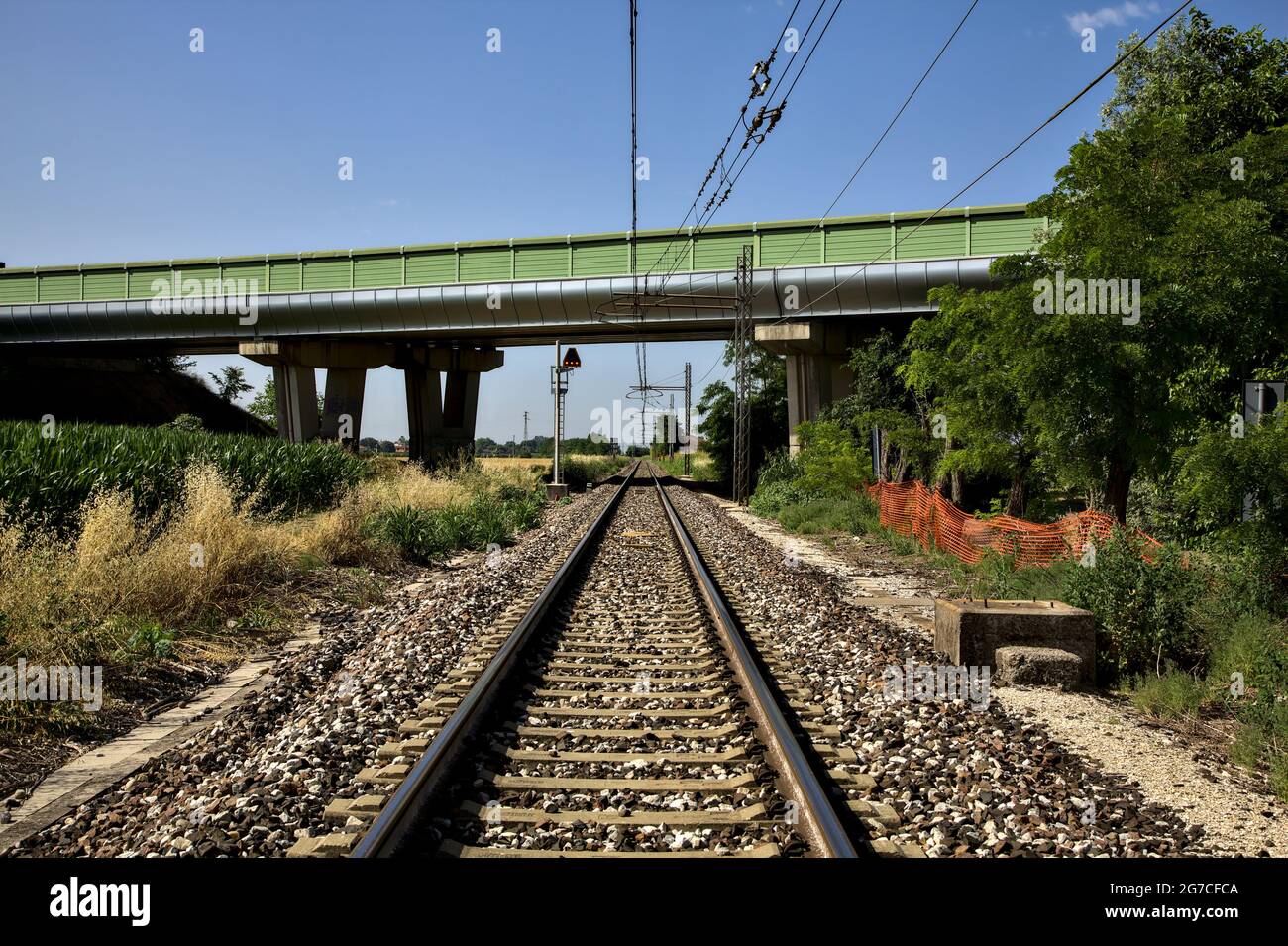 Railroad track that passes under a viaduct in the italian countryside ...