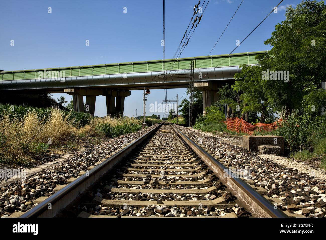 Railroad track that passes under a viaduct in the italian countryside ...