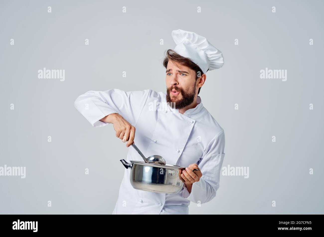 male chef with a saucepan in his hands cooking food working in a ...