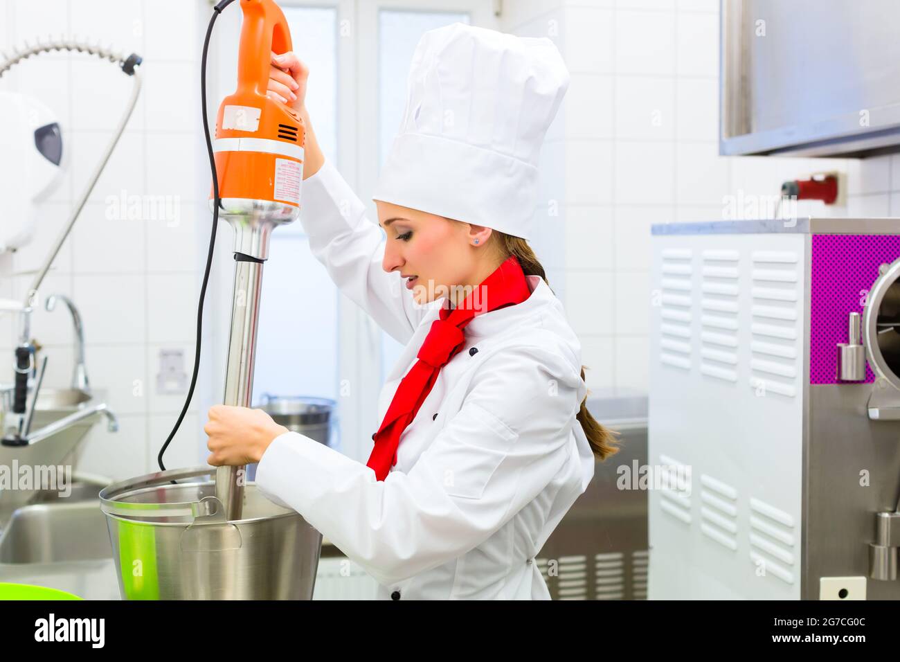 Female Chef preparing ice cream with food processor in gastronomy ...