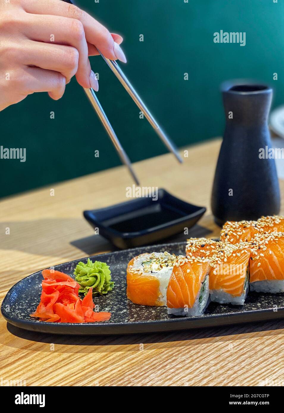 Eating roll sushi in japanese restaurant, hand with chopsticks Stock ...