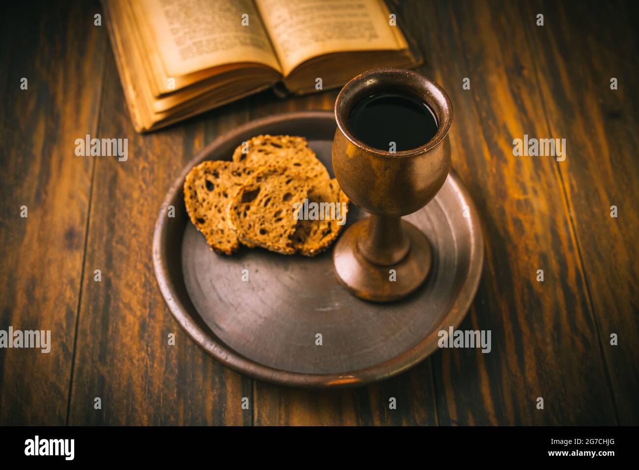 The sacrament of holy communion - bread, wine and bible on wooden table ...